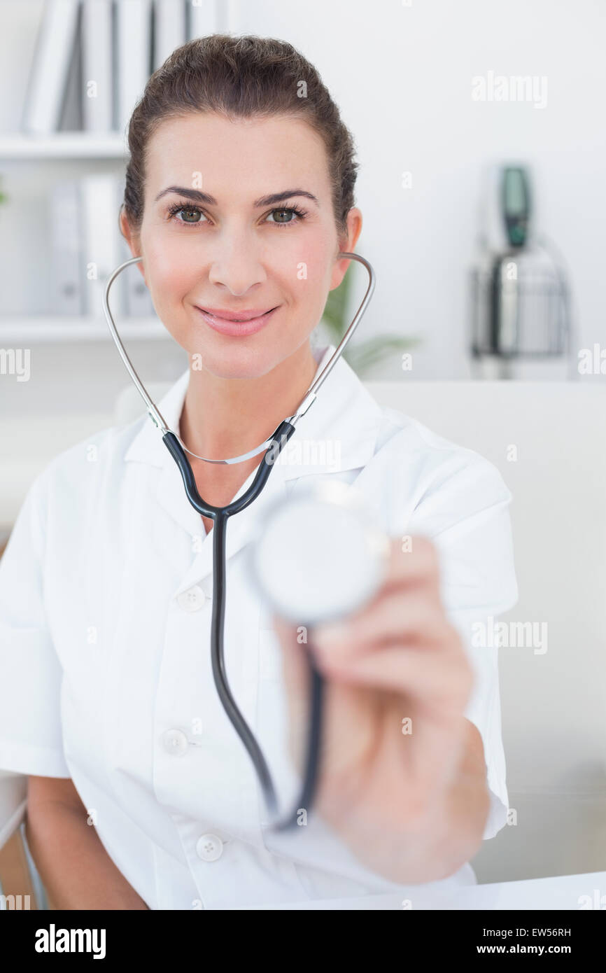 Happy doctor showing stethoscope to camera Stock Photo - Alamy