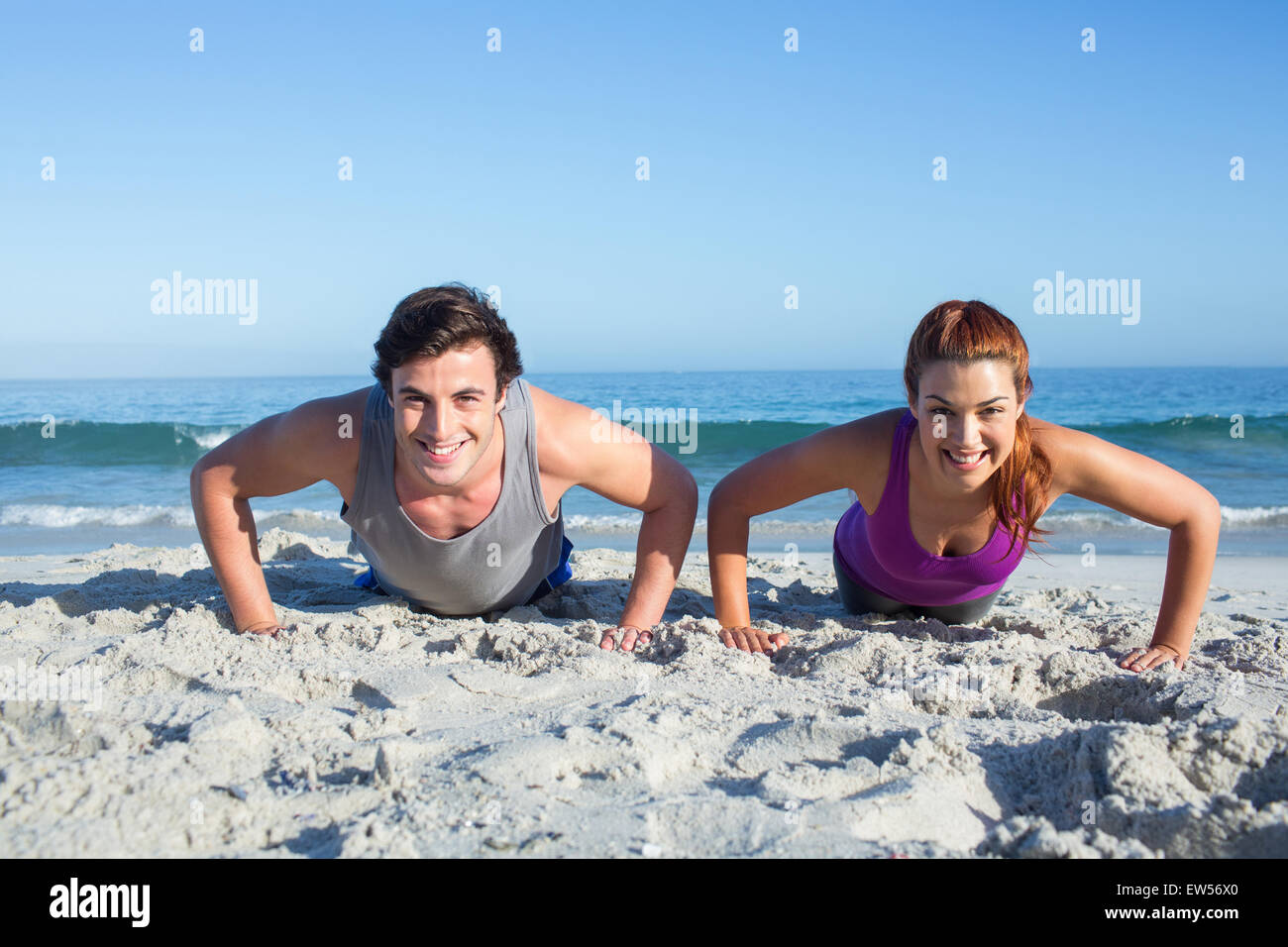 Happy couple doing push ups together Stock Photo - Alamy