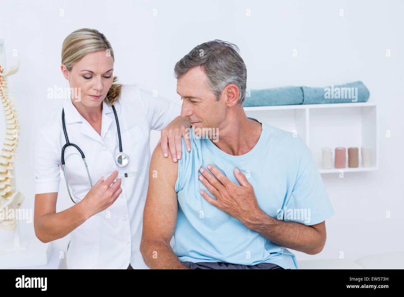 Doctor doing an injection to her patient Stock Photo - Alamy