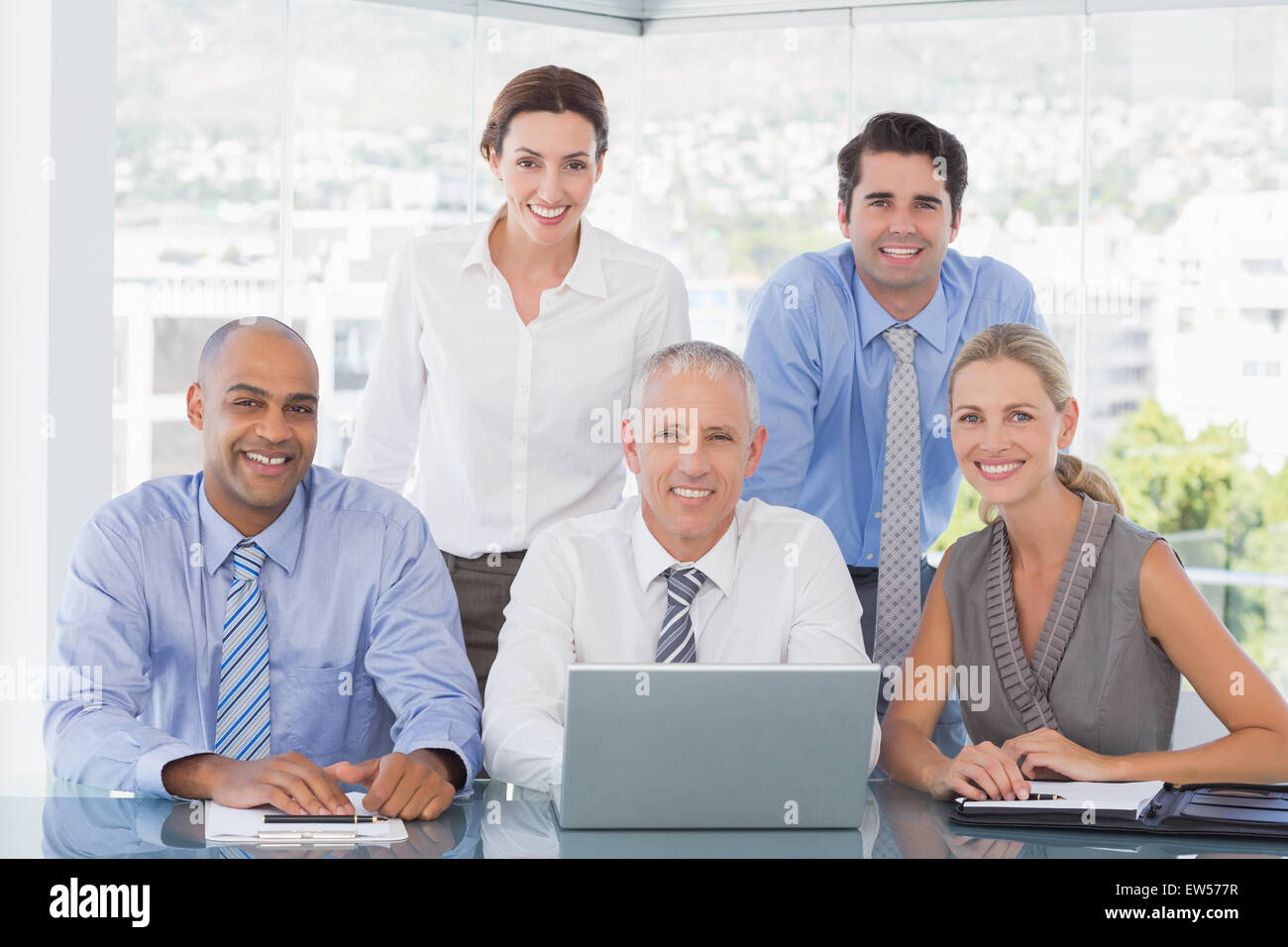 Business team during meeting smiling at camera Stock Photo - Alamy