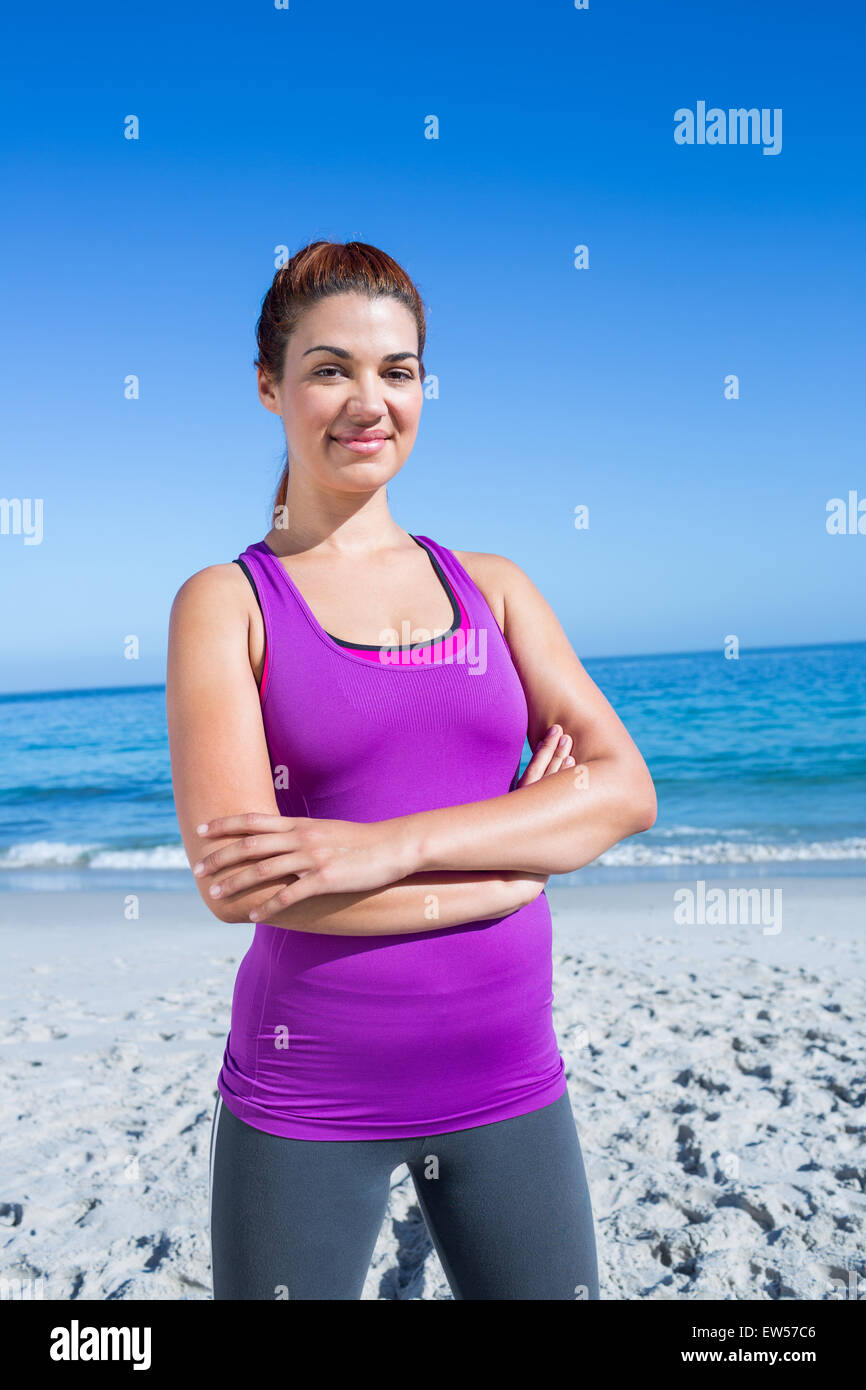 Fit brunette looking at camera arms crossed Stock Photo - Alamy