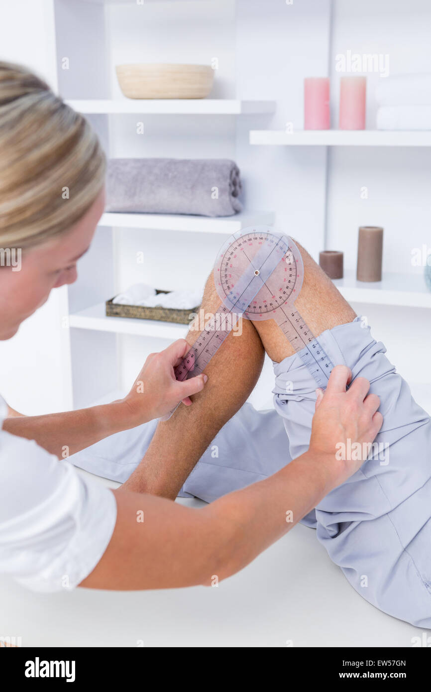 Doctor examining man leg with tool Stock Photo - Alamy