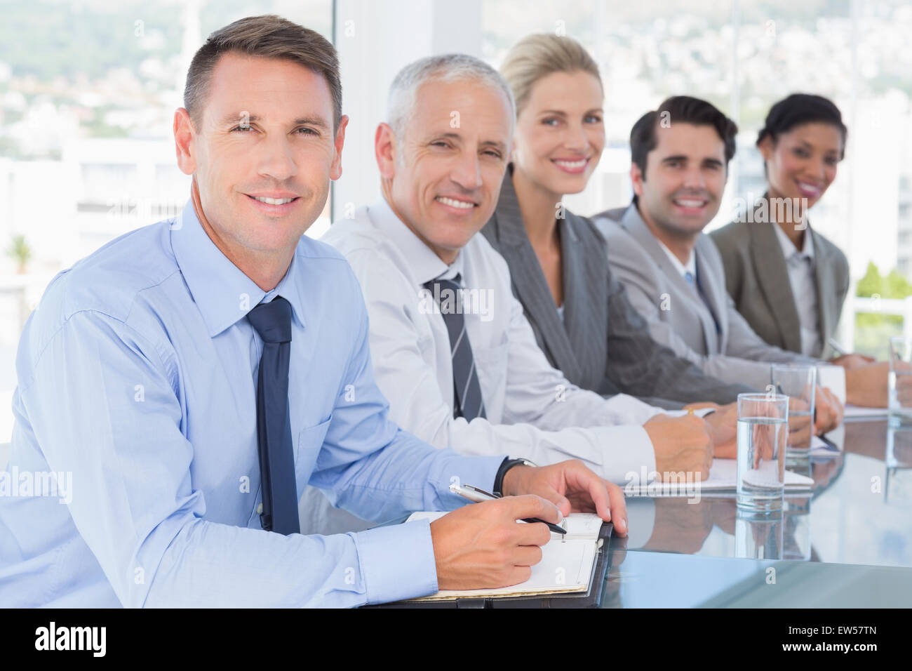 Business team smiling at camera during conference Stock Photo - Alamy