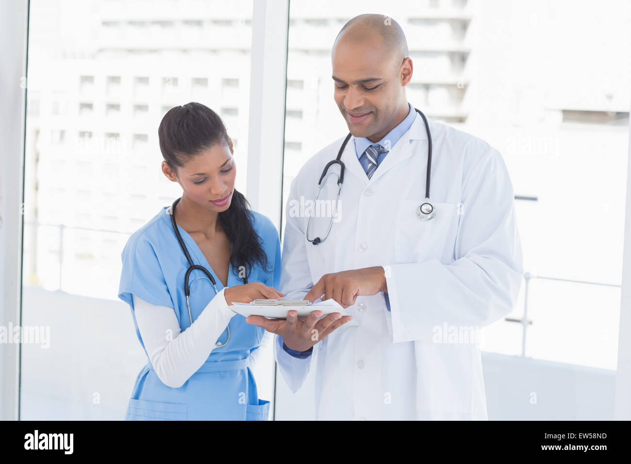 Smiling doctors reading files Stock Photo - Alamy