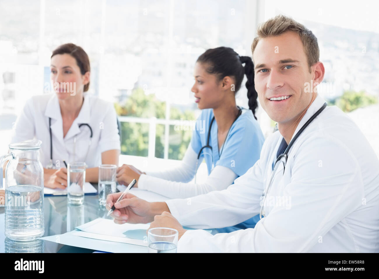 Team of smiling doctors having a meeting Stock Photo - Alamy