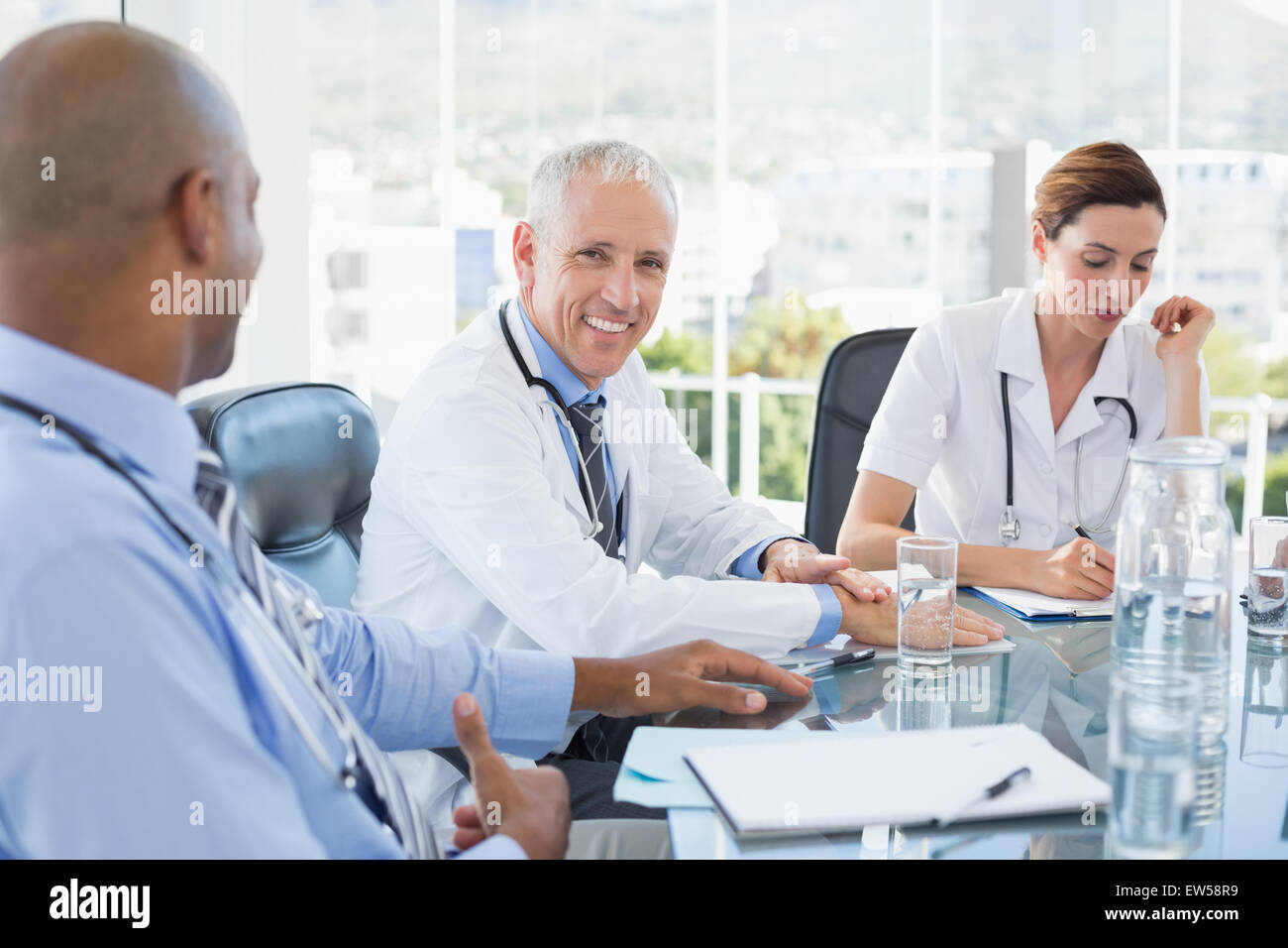 Team of smiling doctors having a meeting Stock Photo - Alamy