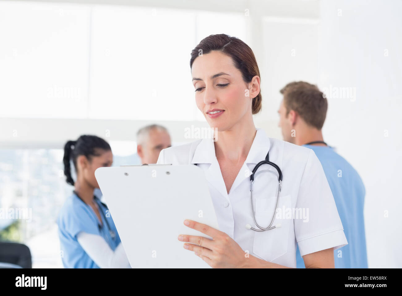 Confident female doctor holding clipboard Stock Photo - Alamy