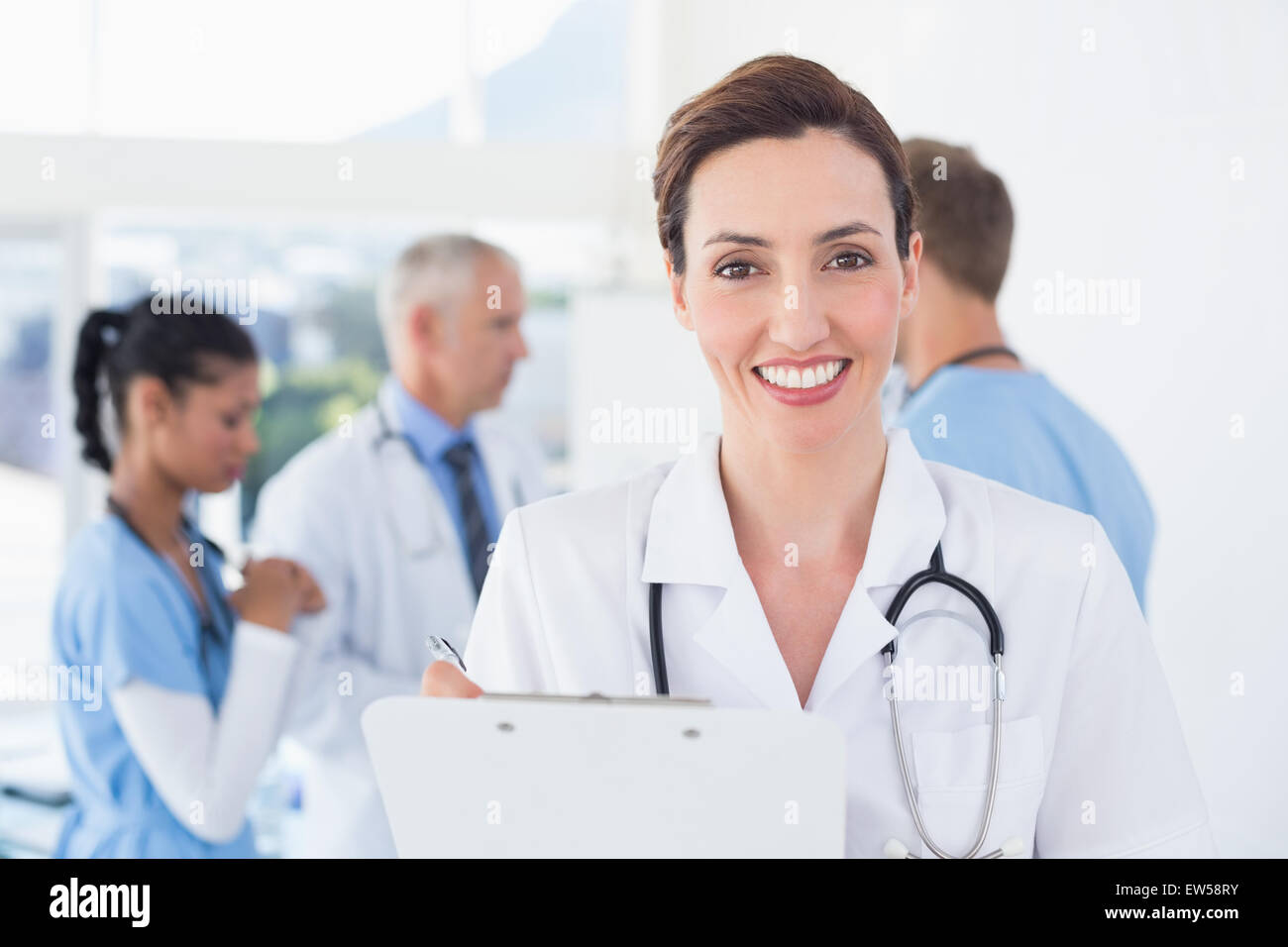 Confident female doctor holding clipboard Stock Photo - Alamy