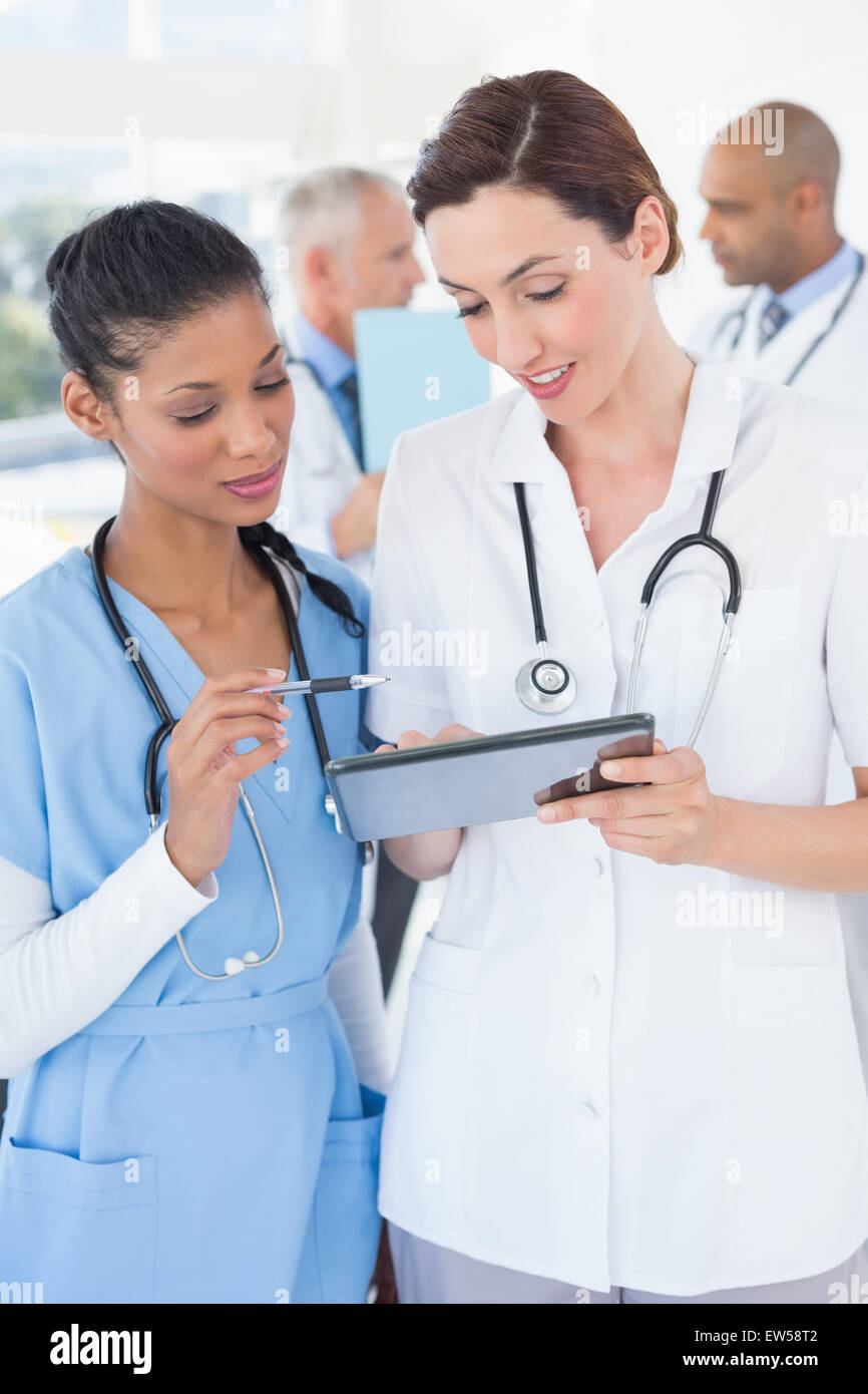 Beautiful female doctors working together with tablet Stock Photo - Alamy
