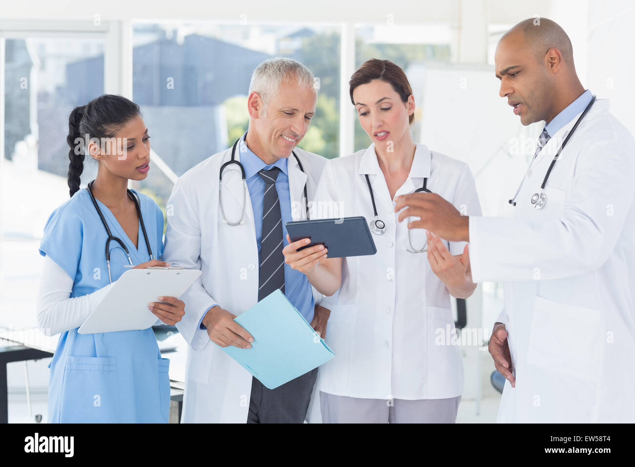Team of doctors working together on patients file Stock Photo - Alamy