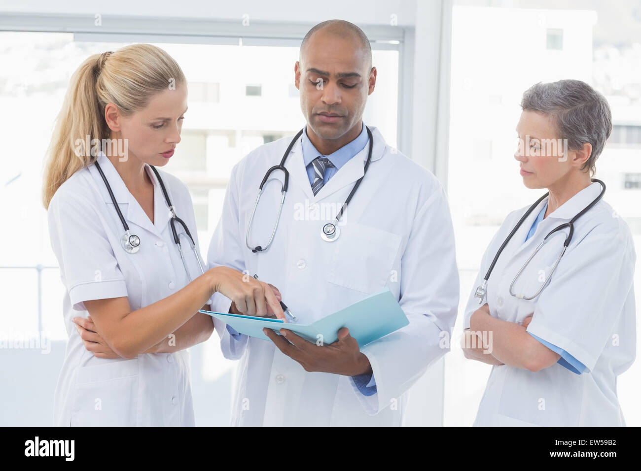 Team of doctors working together on patients file Stock Photo - Alamy