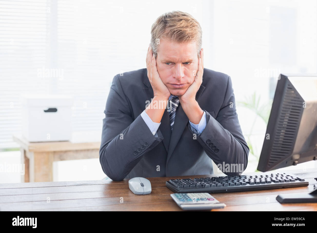 Depressed businessman at his desk Stock Photo - Alamy
