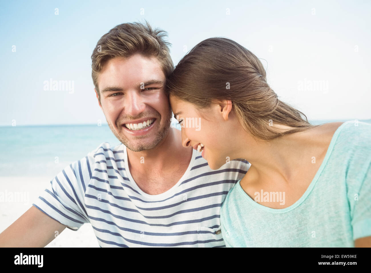 happy couple smiling together in front of the sea Stock Photo - Alamy