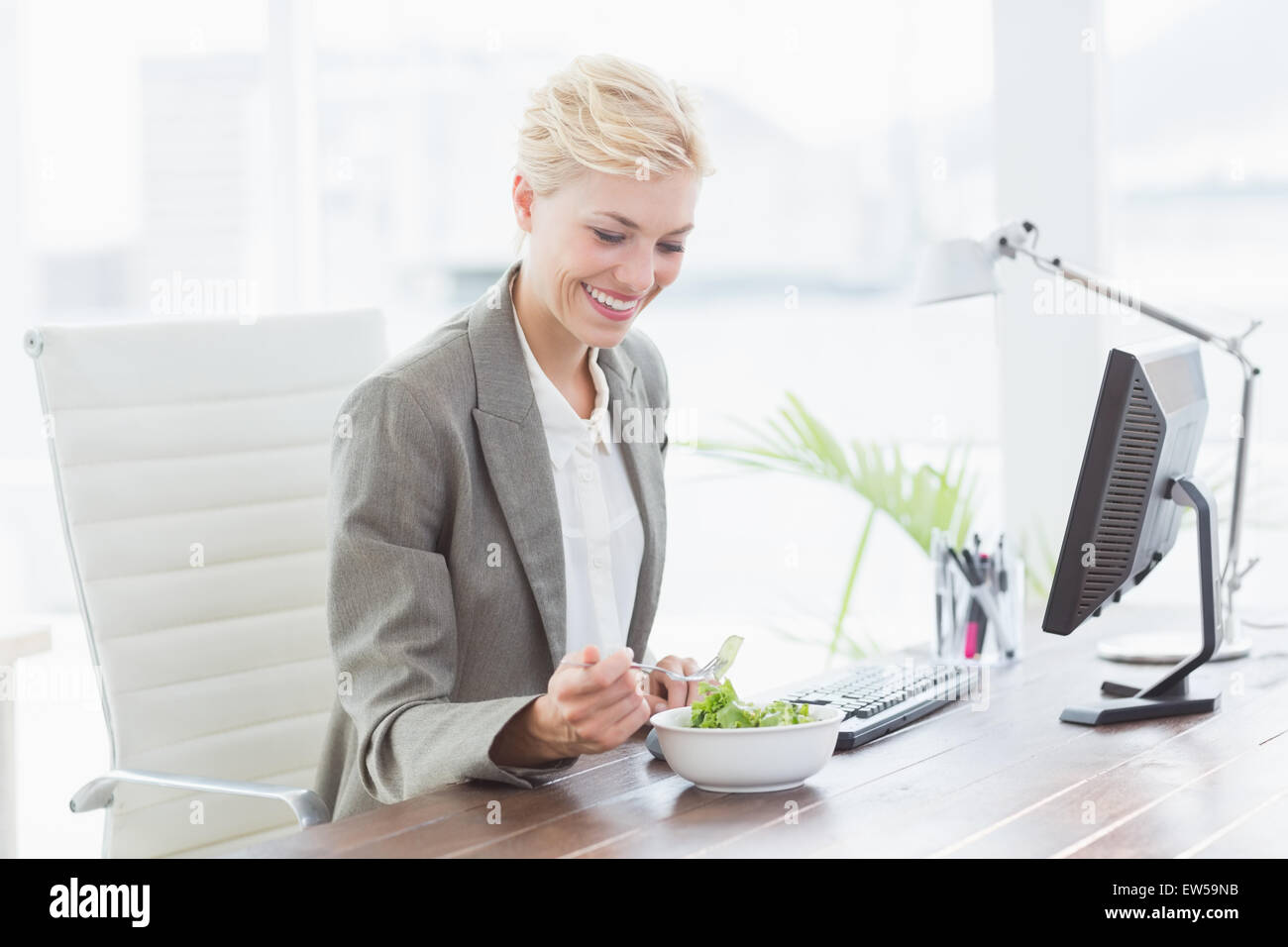 Woman eating salad office desk hi-res stock photography and images - Alamy