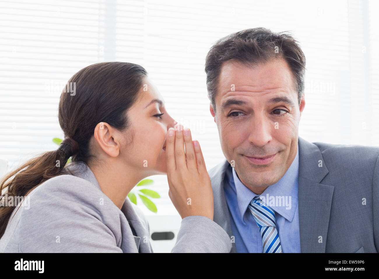Businesswoman whispering something to her colleague Stock Photo - Alamy