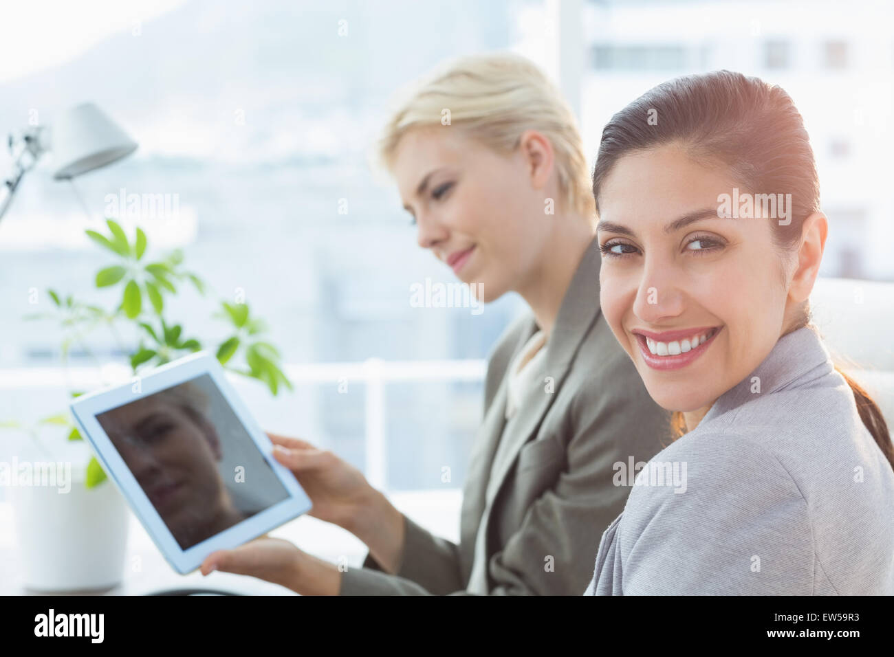 Businesswomen using tablet Stock Photo - Alamy