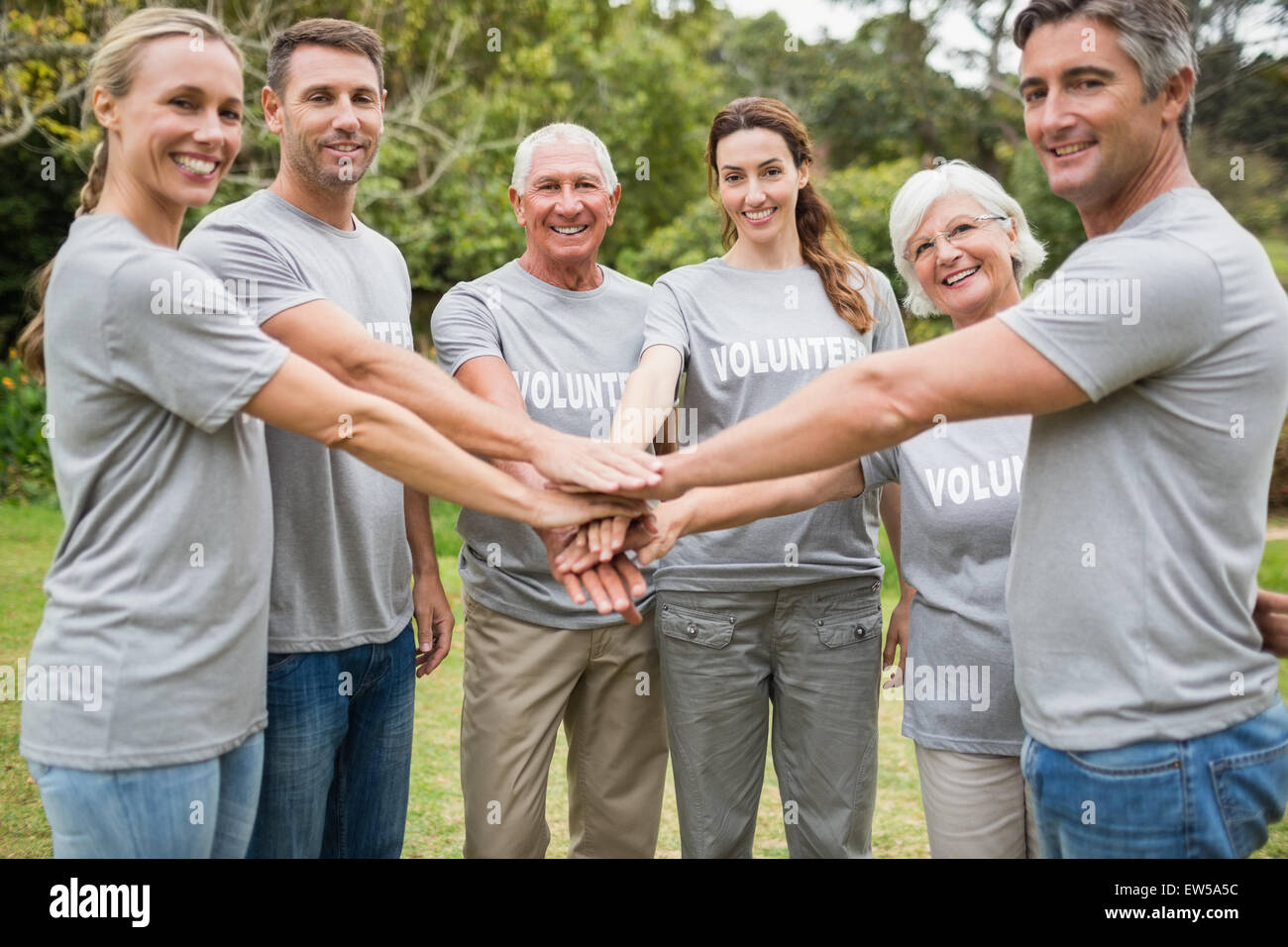Happy volunteer family putting their hands together Stock Photo - Alamy