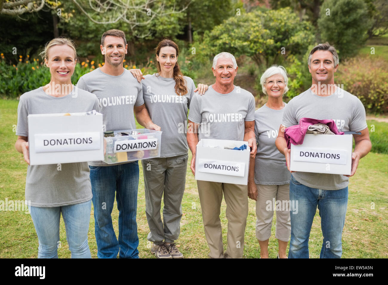 Happy volunteer family holding donations boxes Stock Photo - Alamy