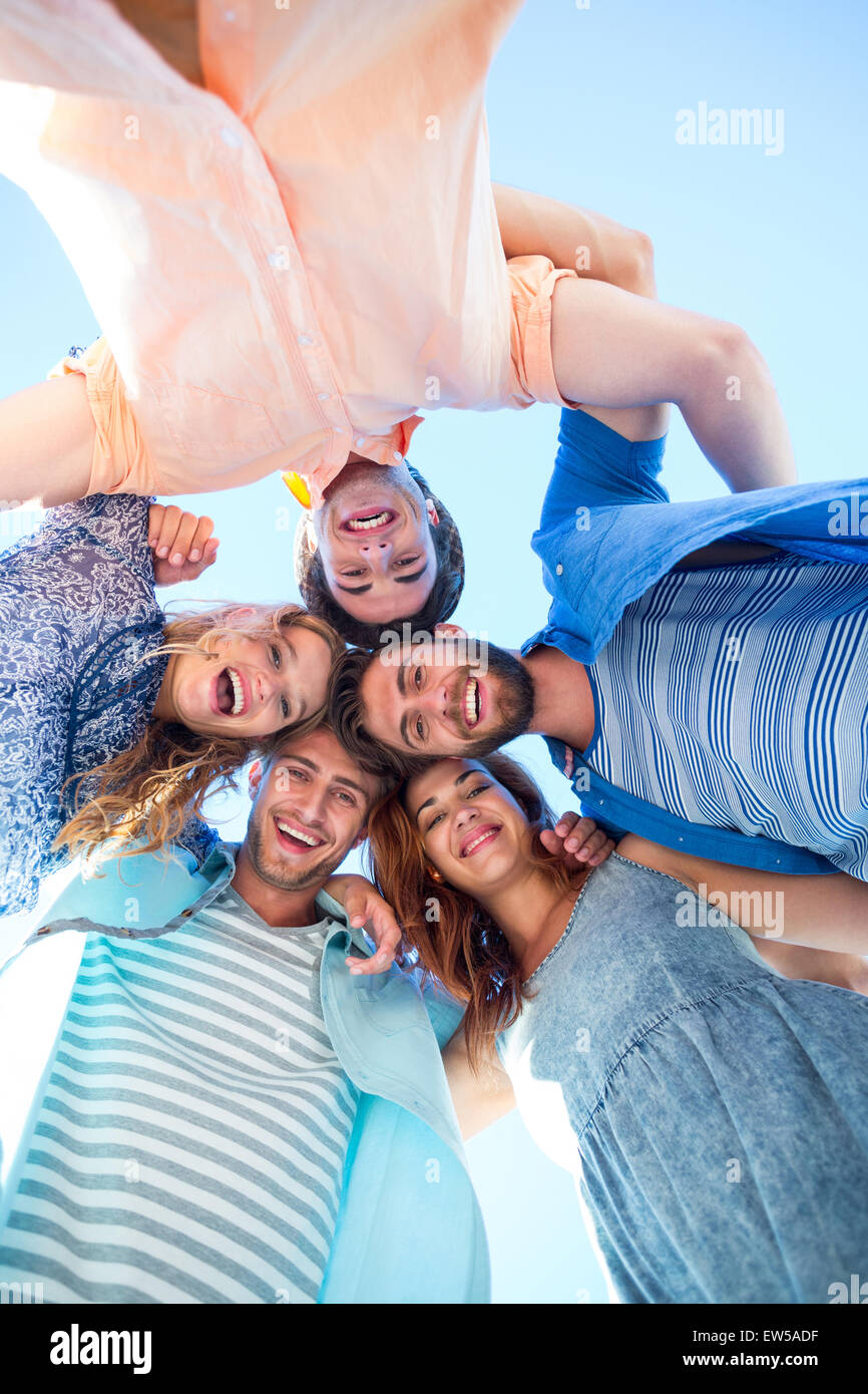 Happy friends standing in circle and looking at camera Stock Photo - Alamy