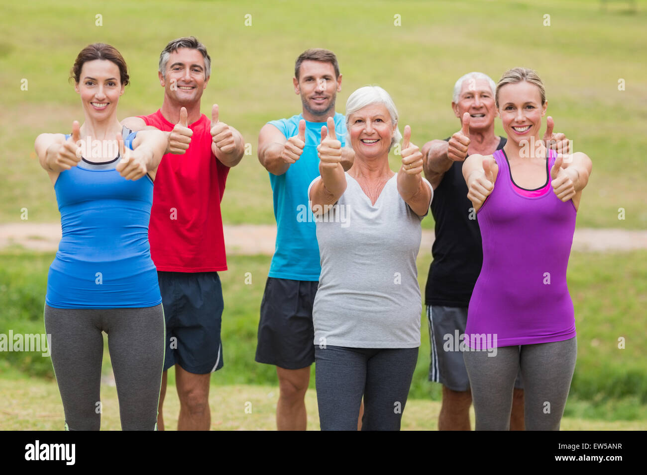 Happy athletic group smiling at camera with thumbs up Stock Photo - Alamy