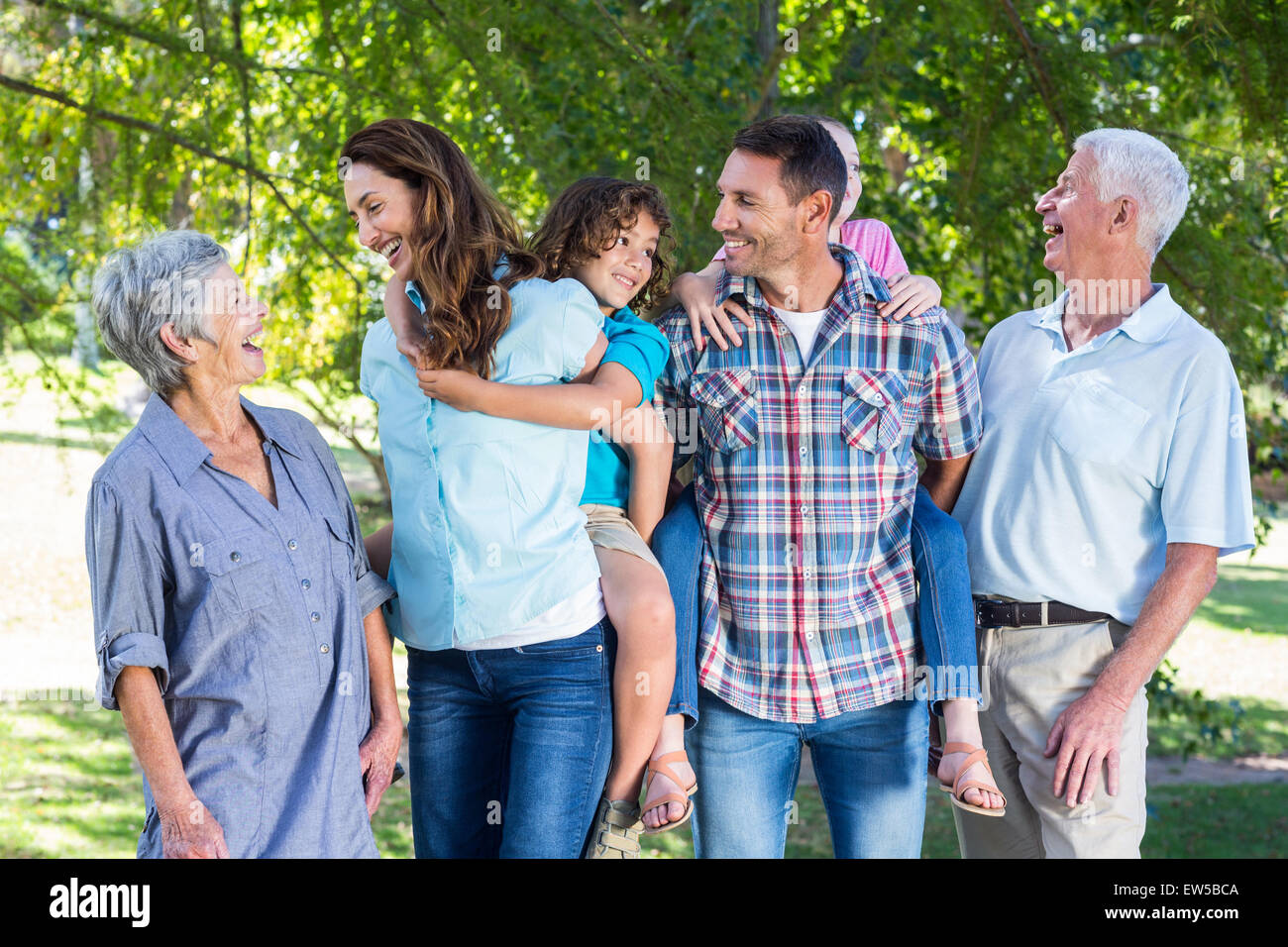Extended family smiling in the park Stock Photo - Alamy