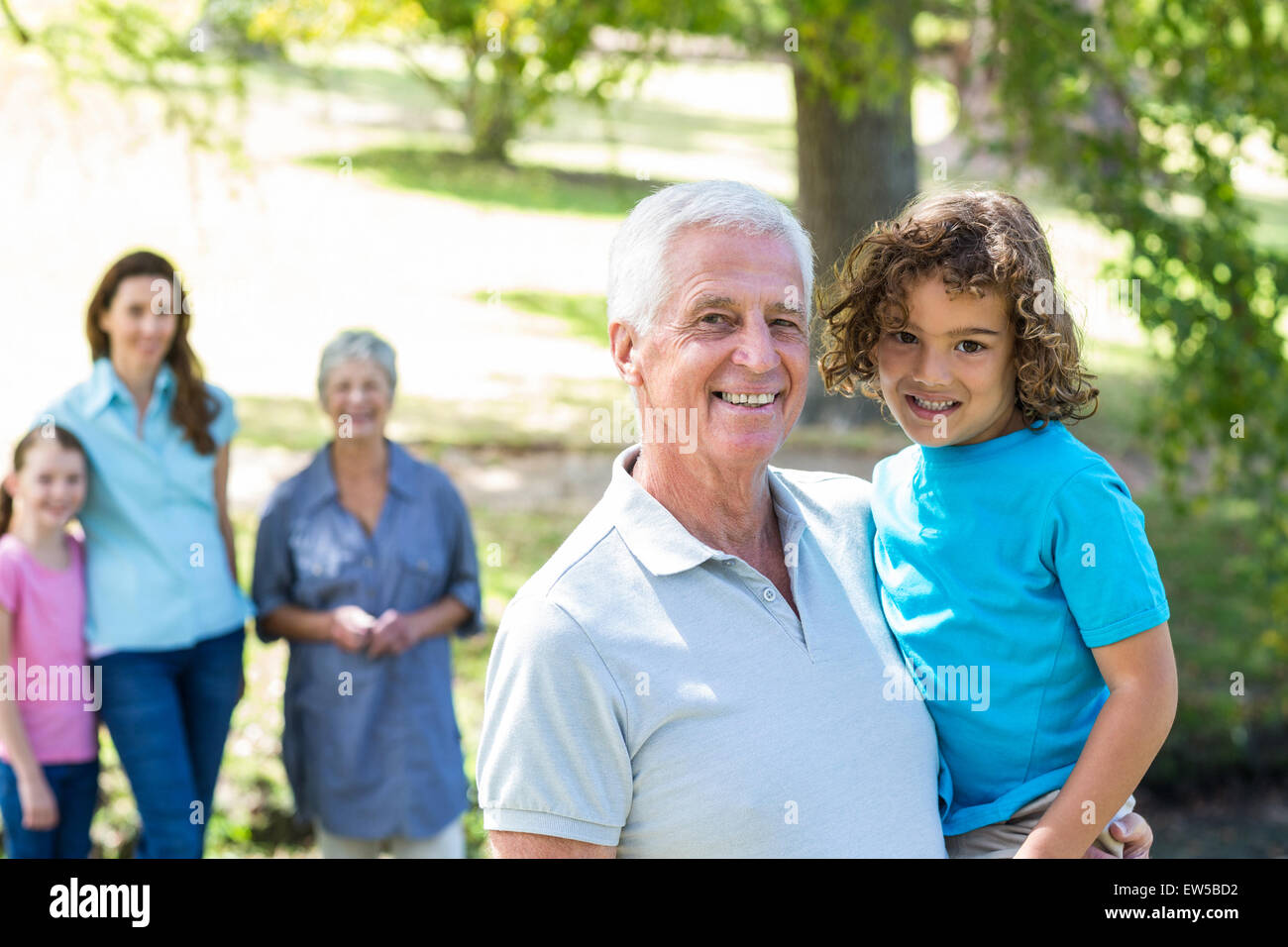 Extended family smiling in the park Stock Photo - Alamy