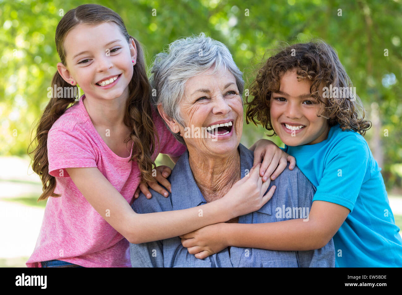 Extended family smiling and kissing in a park Stock Photo - Alamy