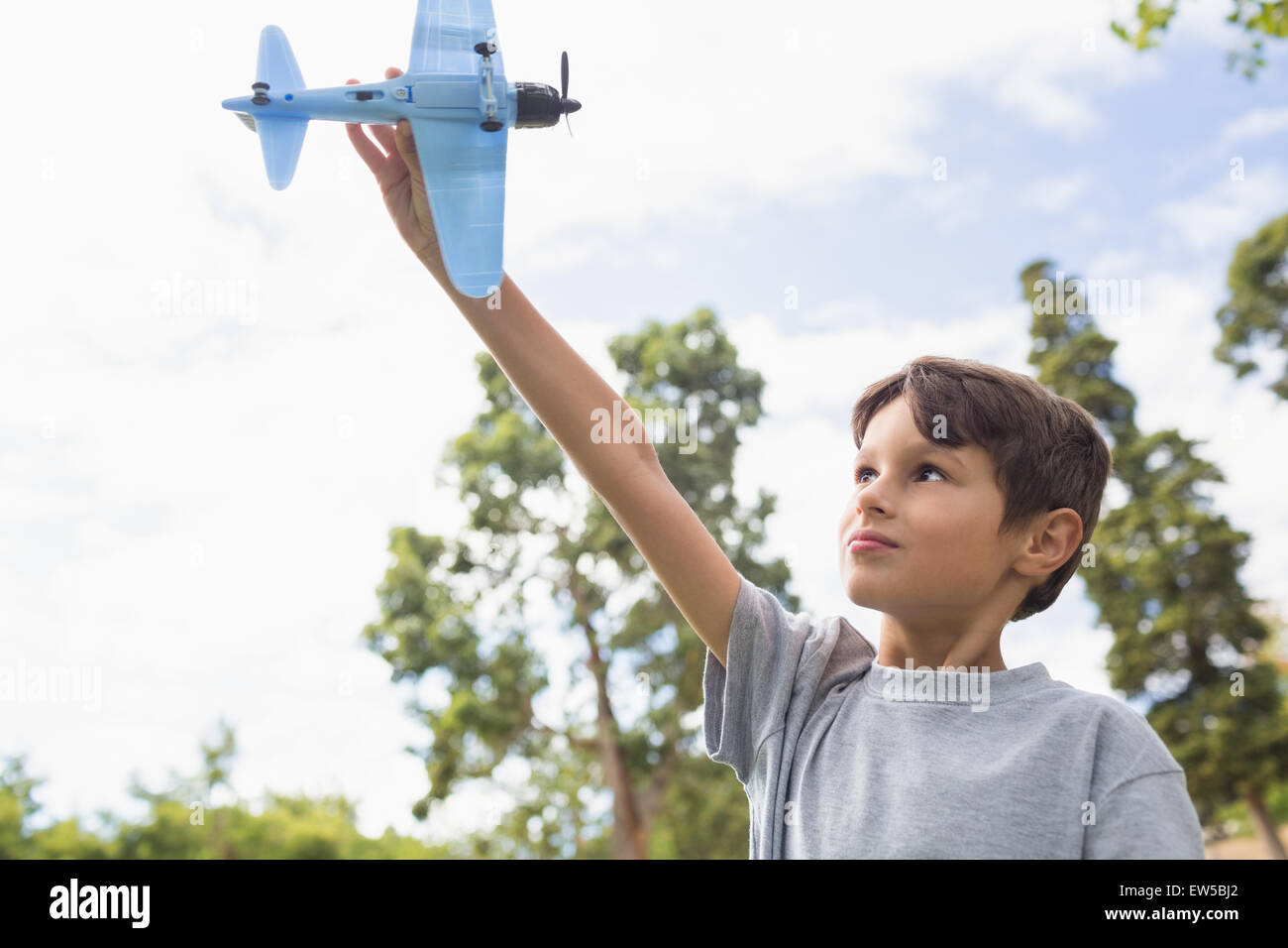 Boy playing with a toy plane at park Stock Photo - Alamy