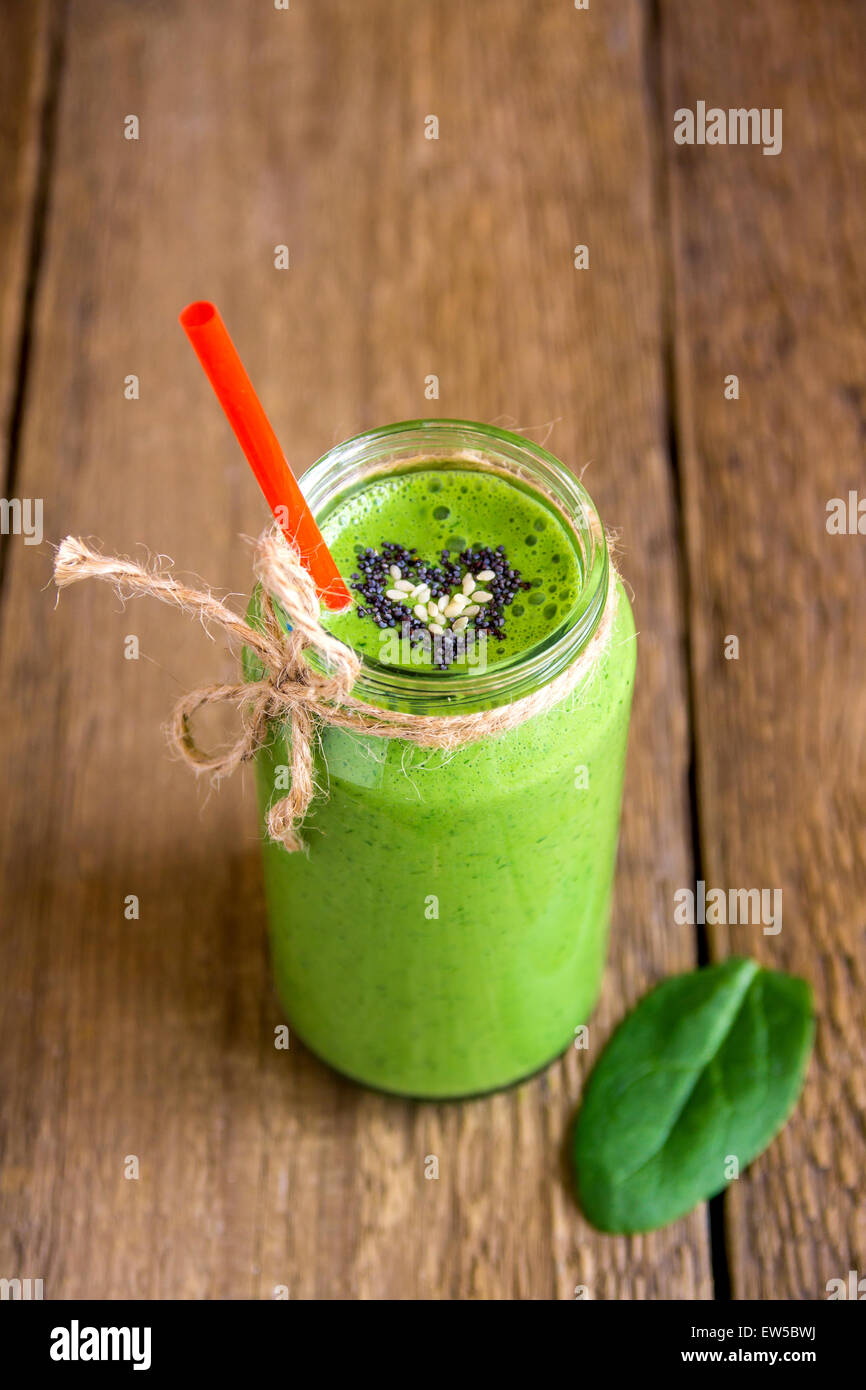 Green vegetable and herbs smoothie with heart of poppy and sesame seeds ...