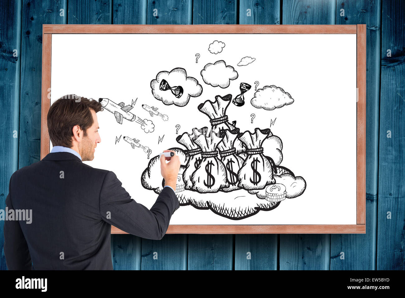 Composite image of businessman standing back to camera writing with ...