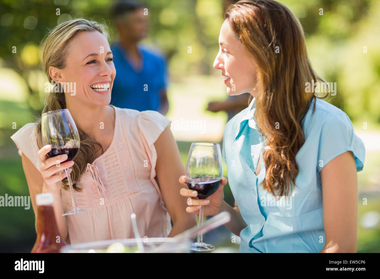 Happy friends drinking at the park Stock Photo - Alamy