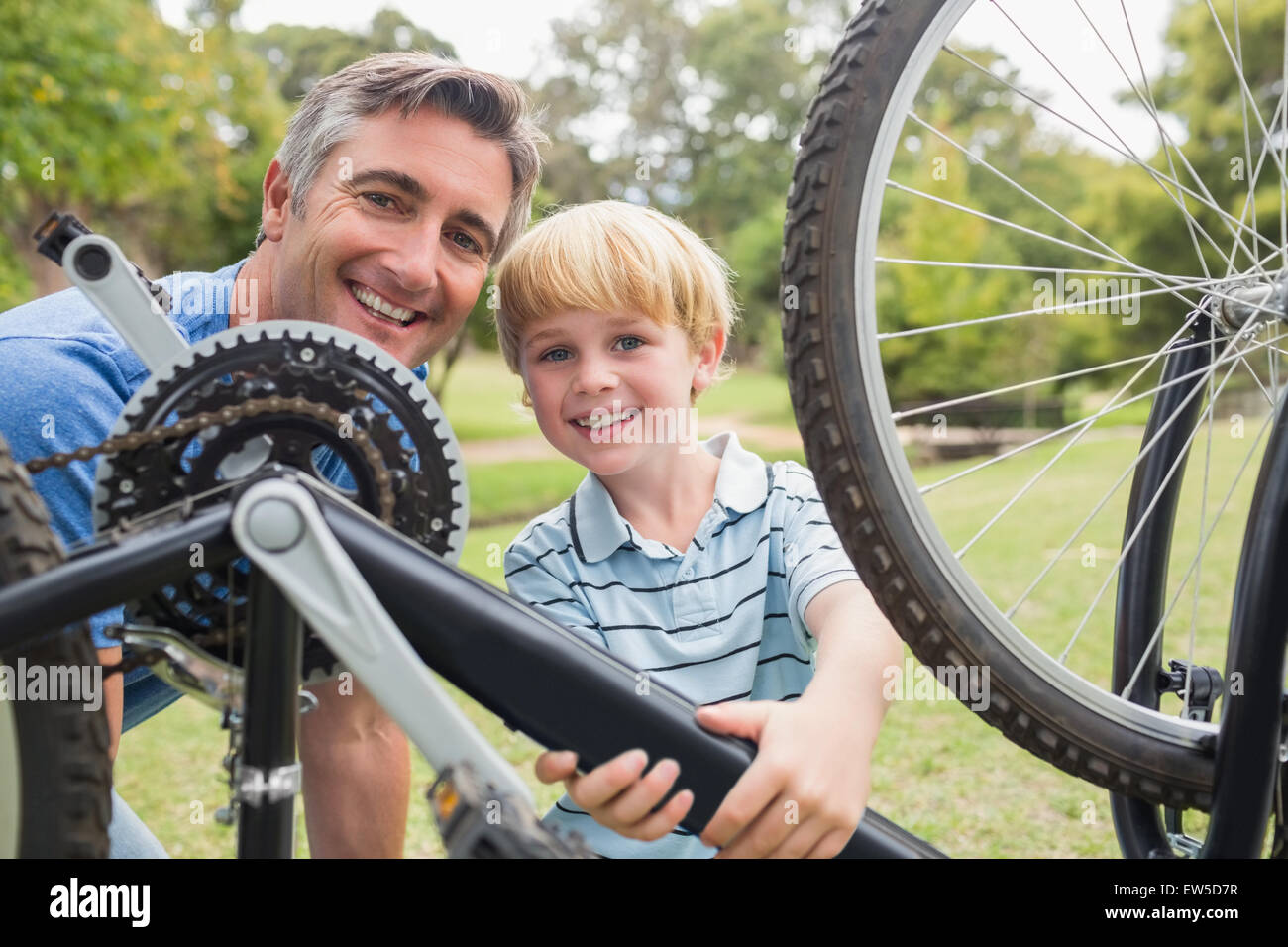Happy father and his son fixing a bike Stock Photo - Alamy