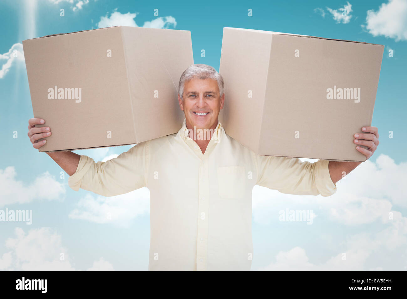 Composite image of happy man holding boxes Stock Photo - Alamy