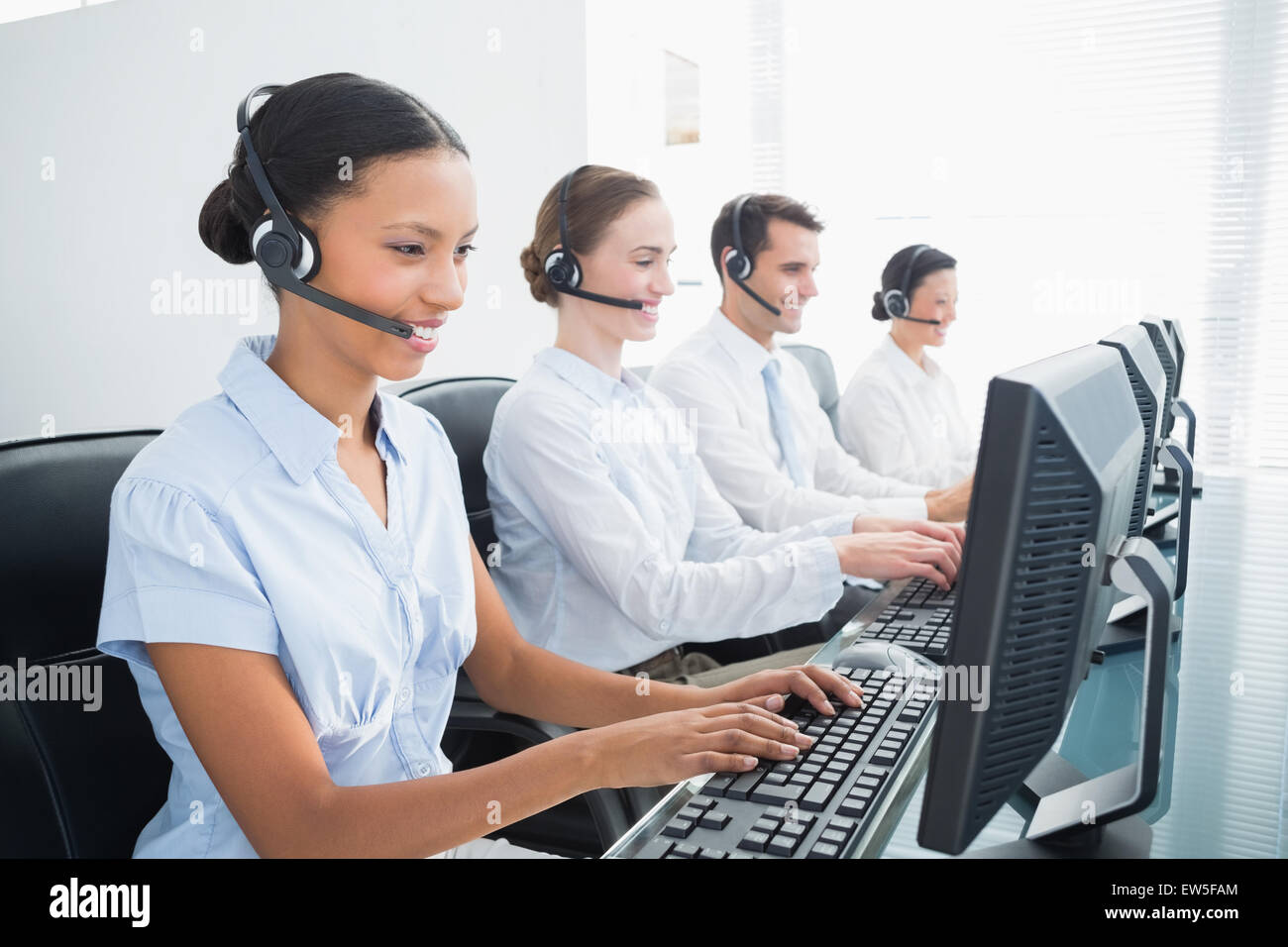 Business people with headsets using computers Stock Photo - Alamy