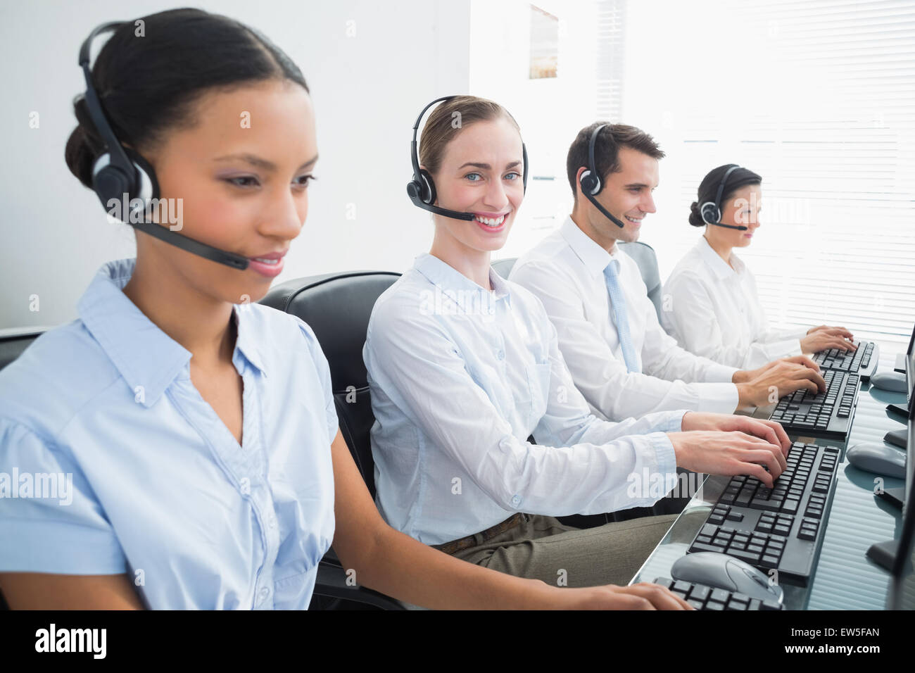 Business people with headsets using computers Stock Photo - Alamy