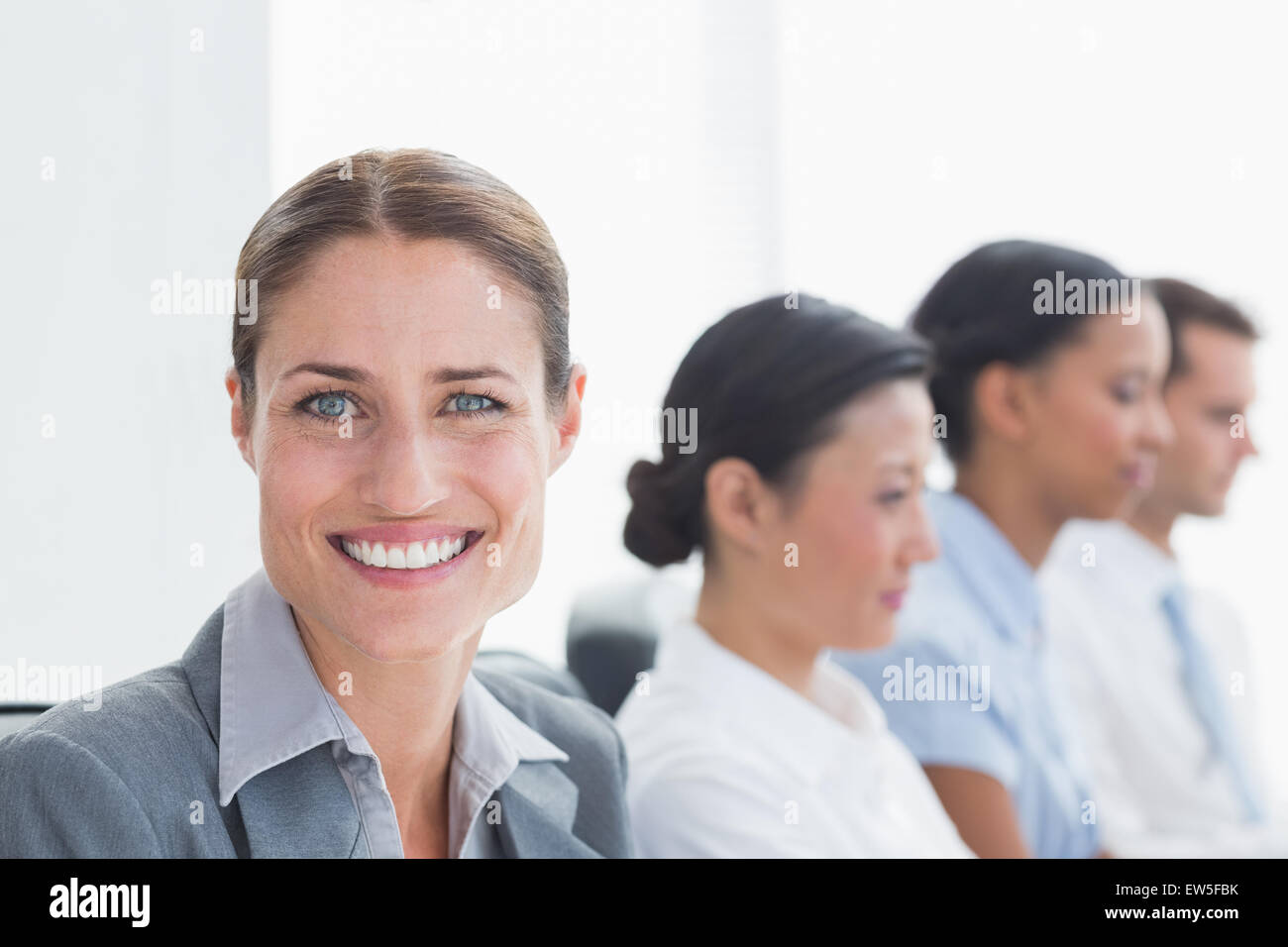 Smiling business people looking at camera Stock Photo - Alamy