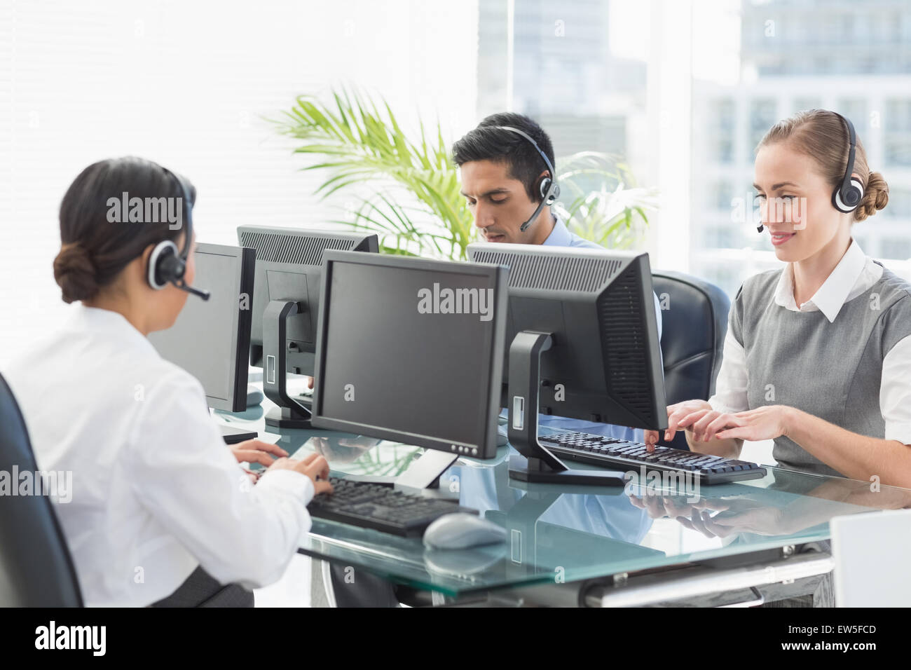 Business people with headsets using computers Stock Photo - Alamy