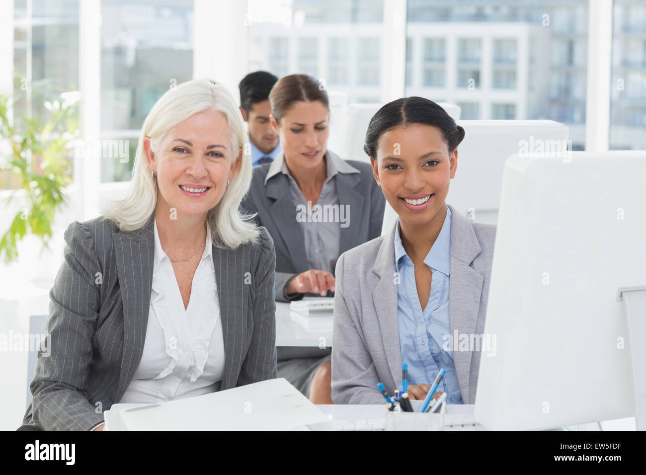 Smiling team work looking at camera Stock Photo - Alamy