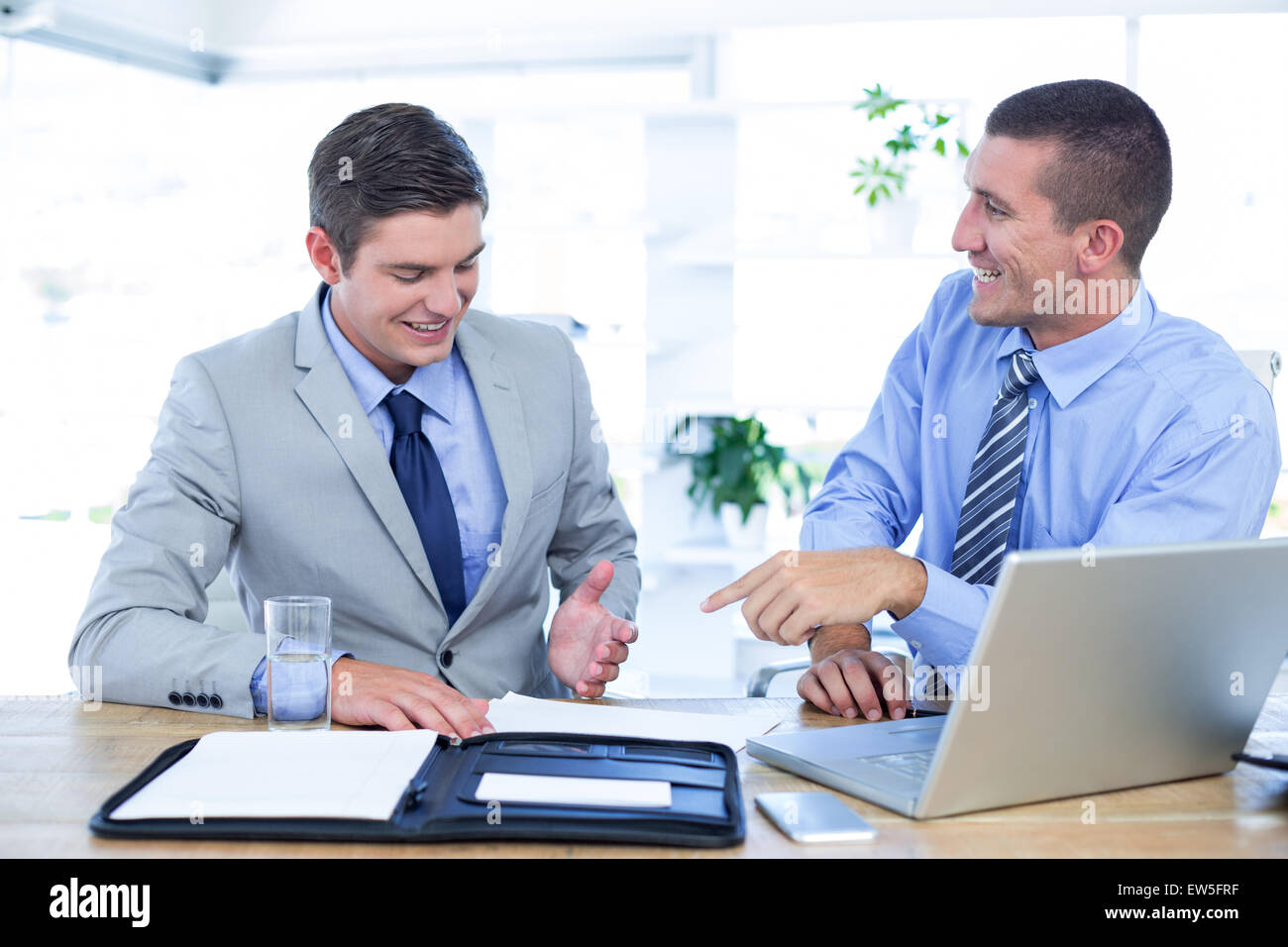 Businessmen working together with laptop Stock Photo - Alamy