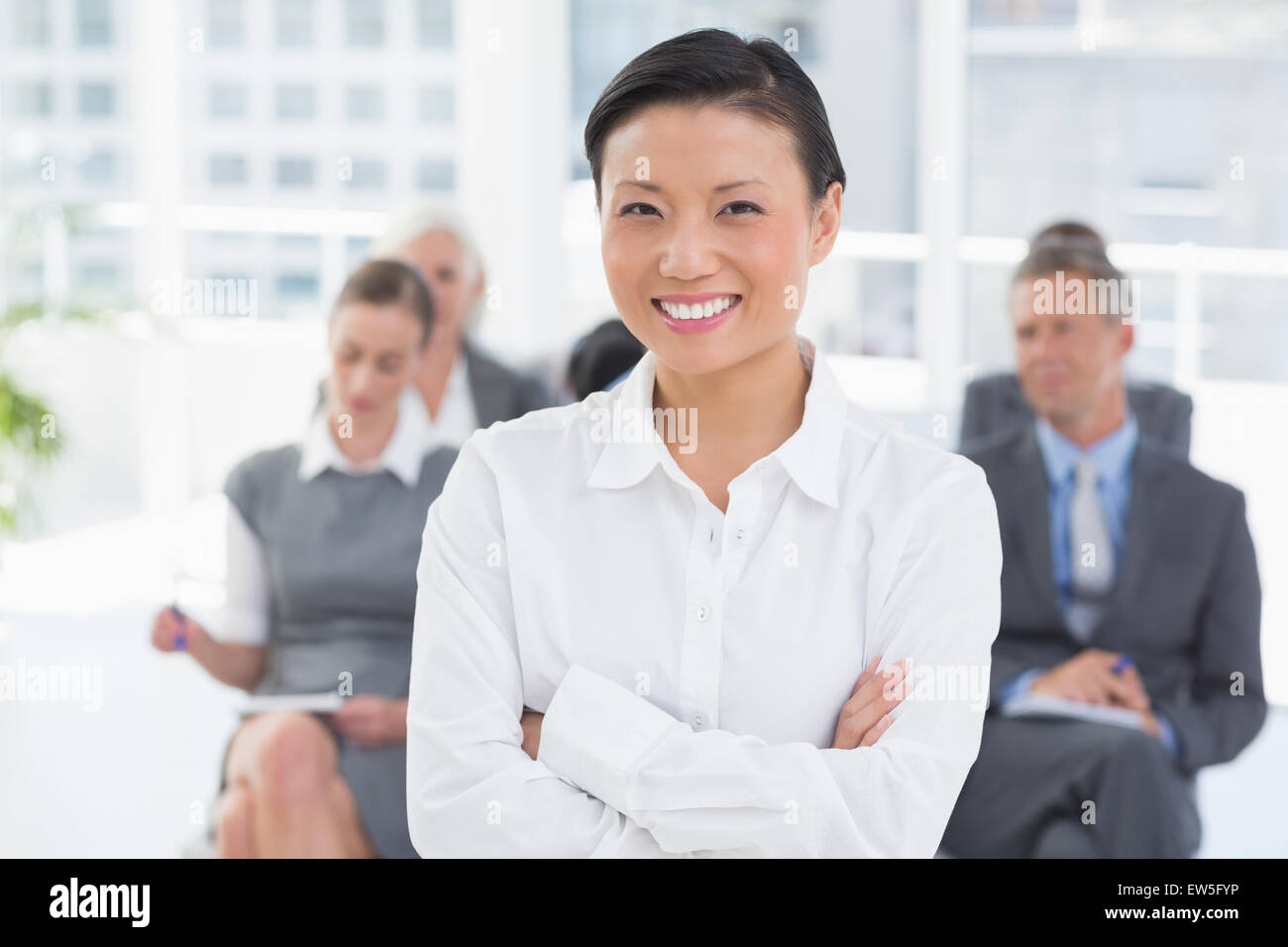 Business people looking at camera with arms crossed Stock Photo - Alamy