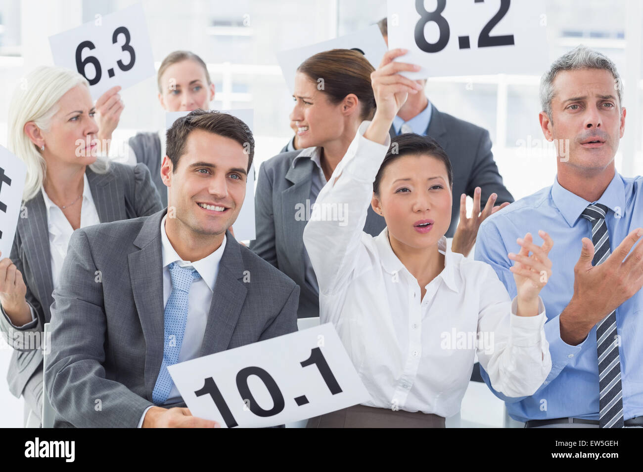 Interview panel holding score cards in office Stock Photo - Alamy