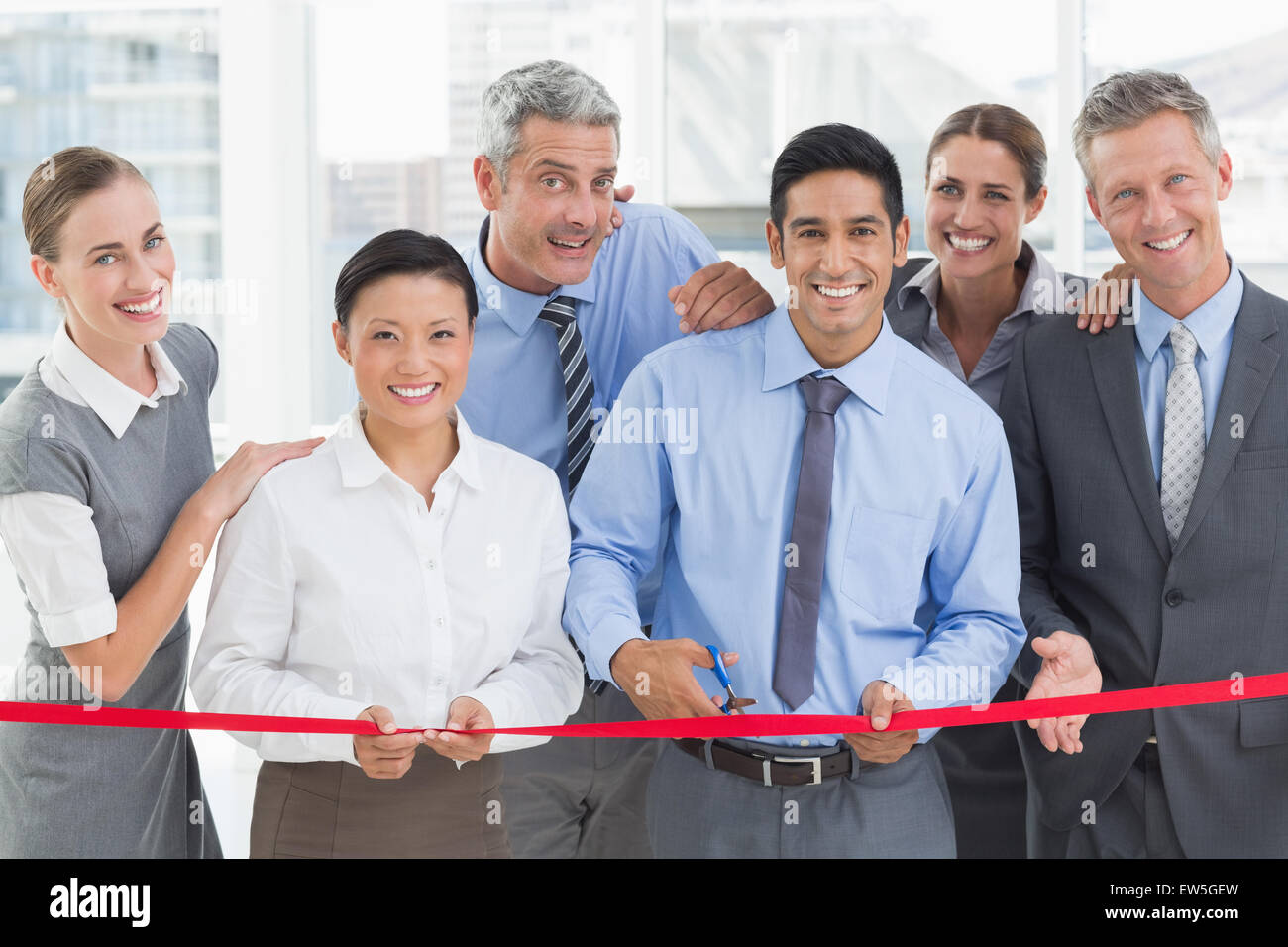 Business man cutting red strip Stock Photo - Alamy