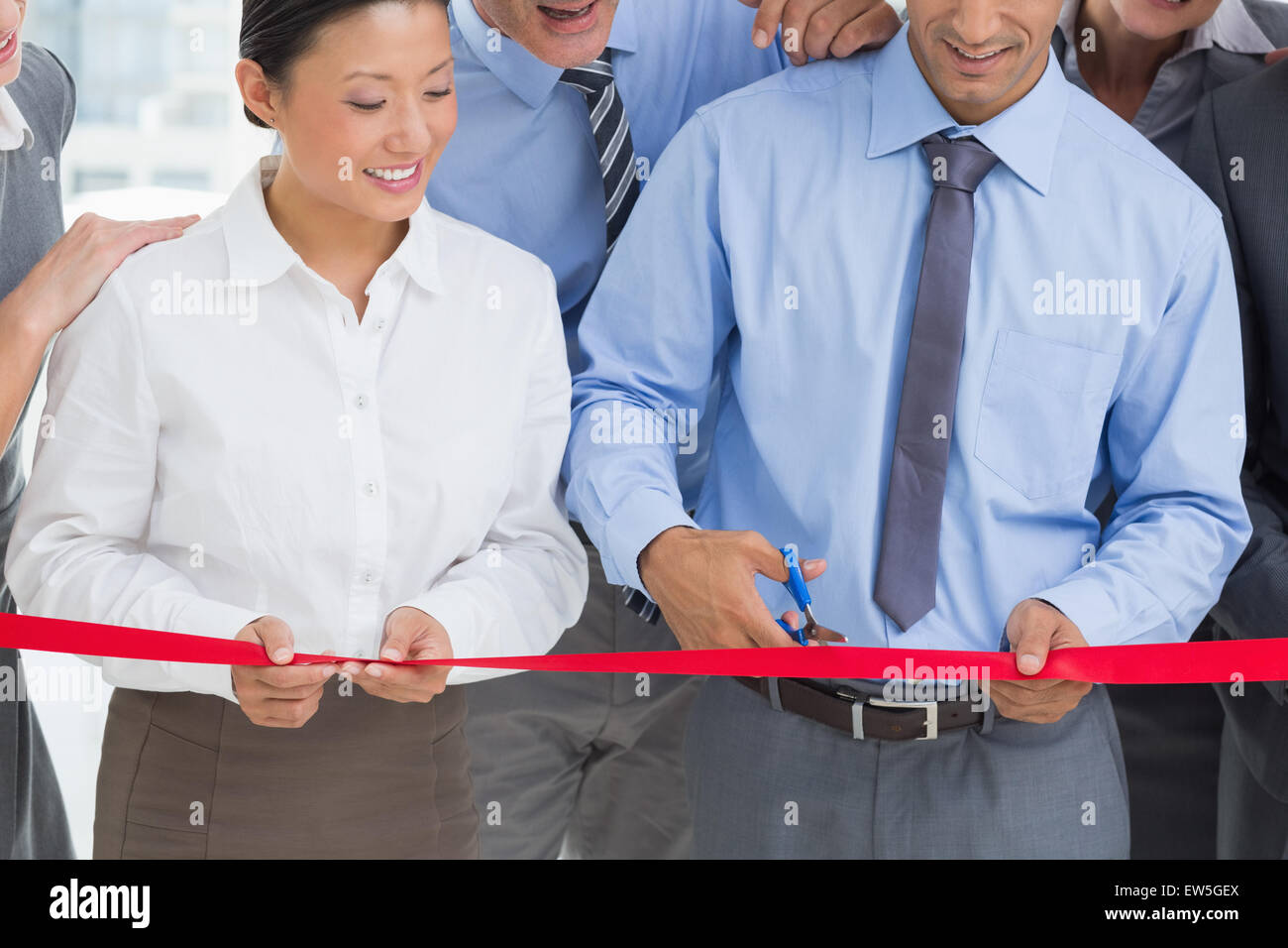 Business man cutting red strip Stock Photo - Alamy