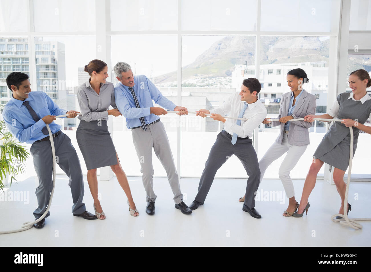 Business people pulling rope Stock Photo - Alamy