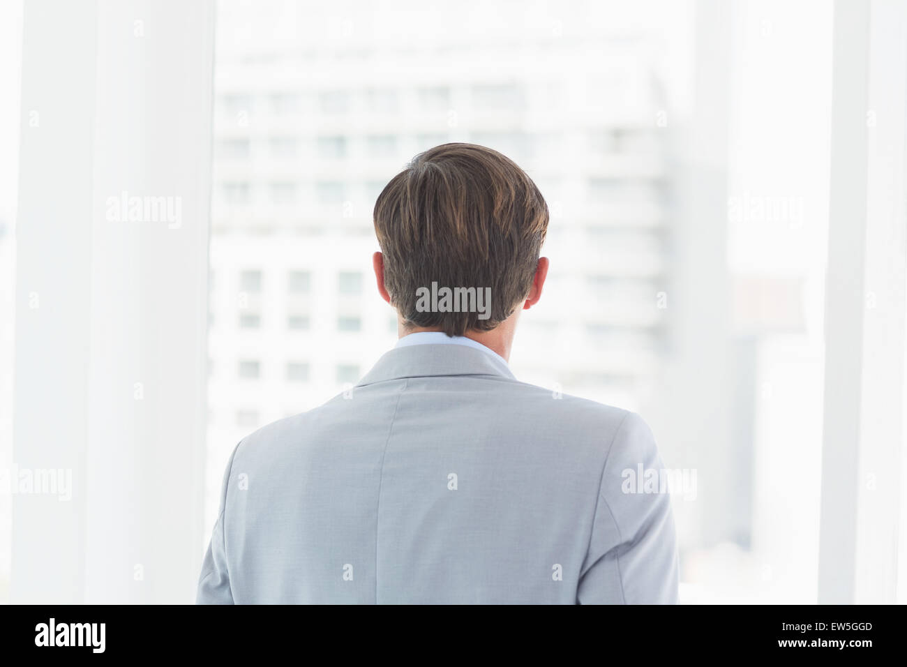 wear view of businessman looking across window Stock Photo - Alamy
