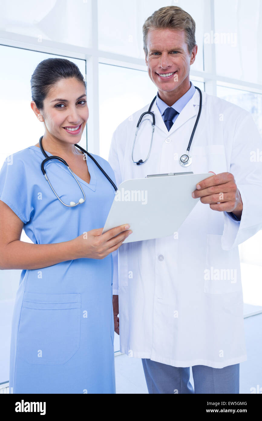 Happy doctors holding clipboard and looking at camera Stock Photo - Alamy