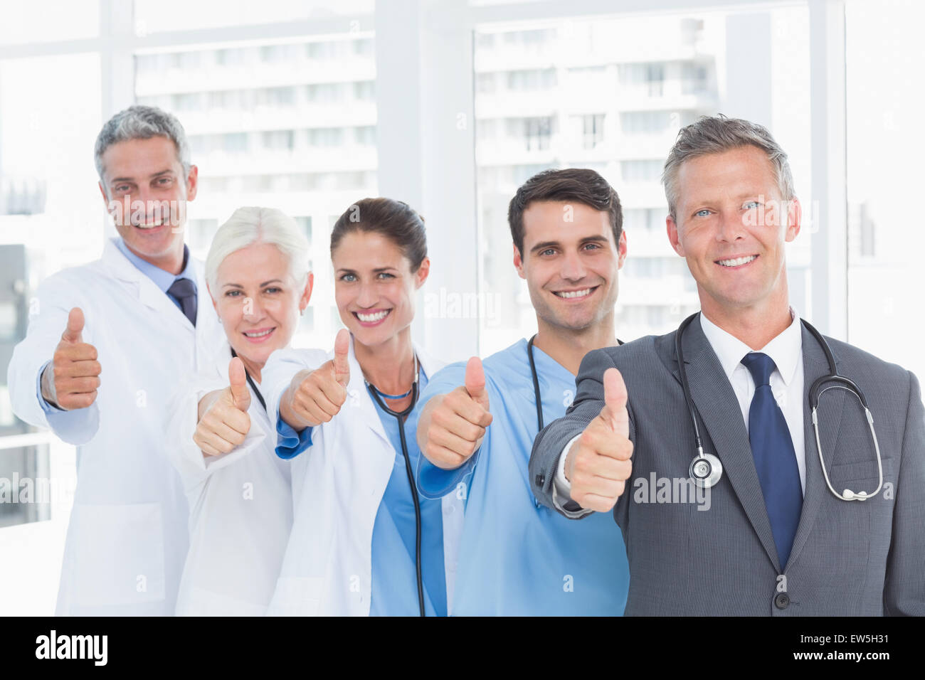 Portrait of confident doctors in row thumbs up Stock Photo - Alamy