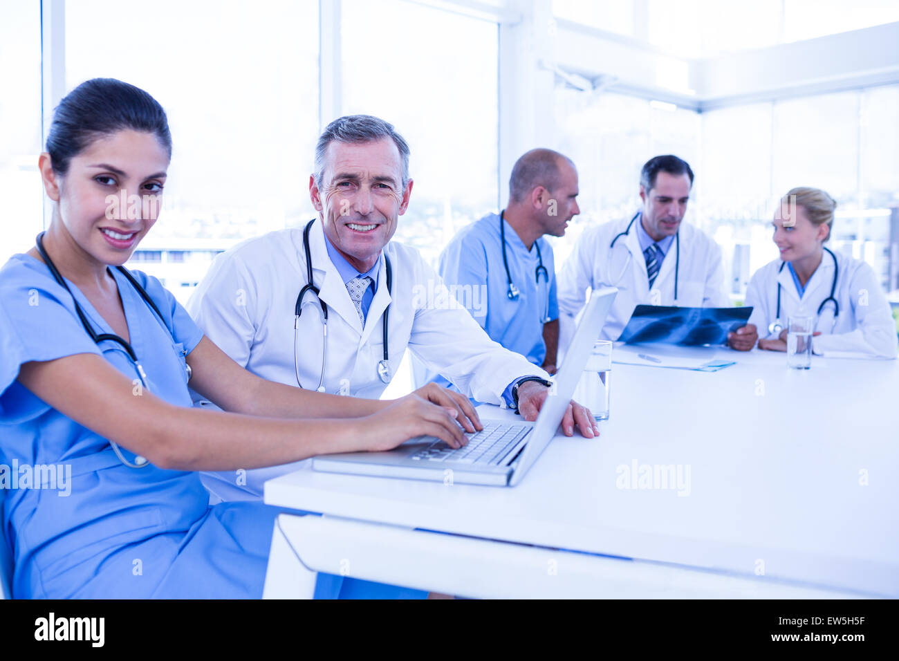 Doctors using computer whiles theirs colleagues looking at Xray Stock ...