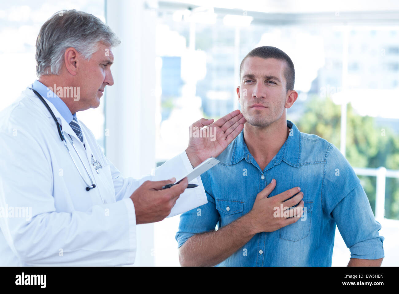 Doctor examining his patients neck Stock Photo - Alamy