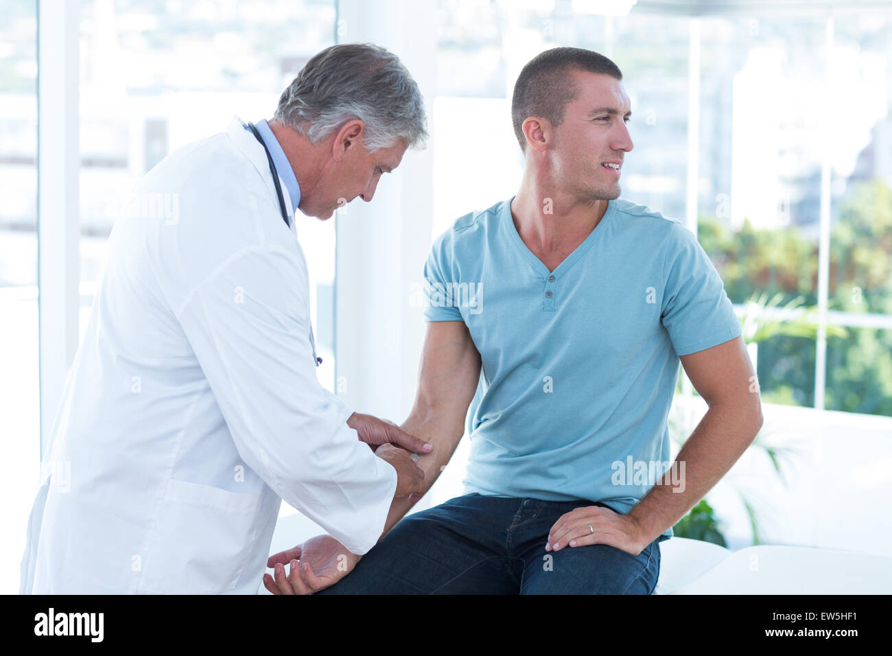 Doctor examining his patients arm Stock Photo - Alamy